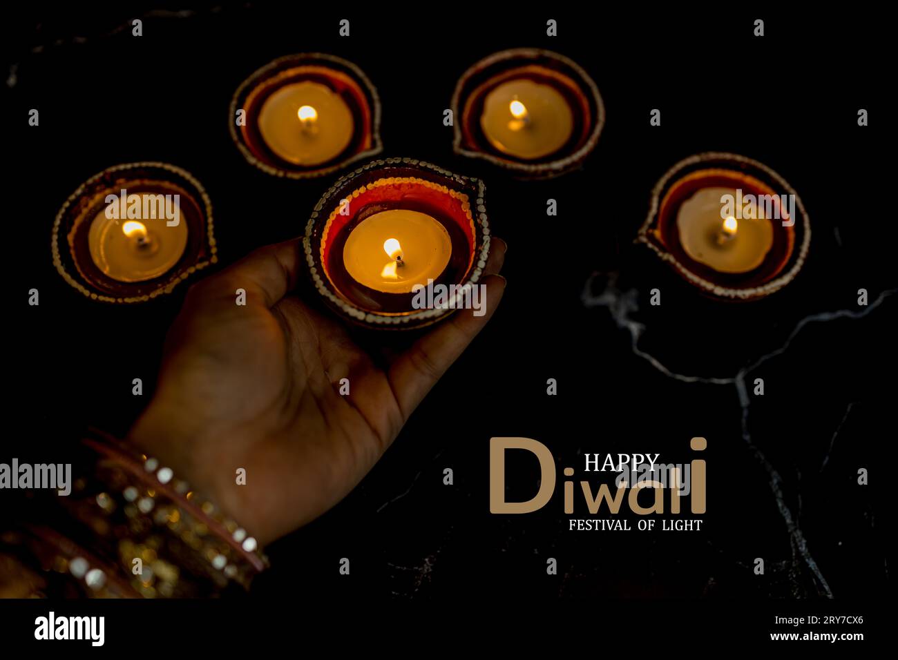 Happy Diwali - Woman hands with henna holding lit candle isolated on ...