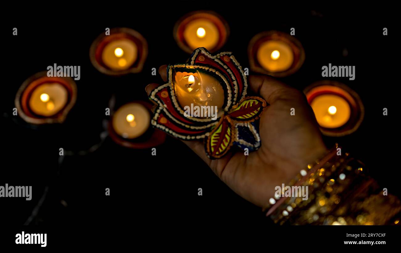 Happy Diwali - Woman hands with henna holding lit candle isolated on ...
