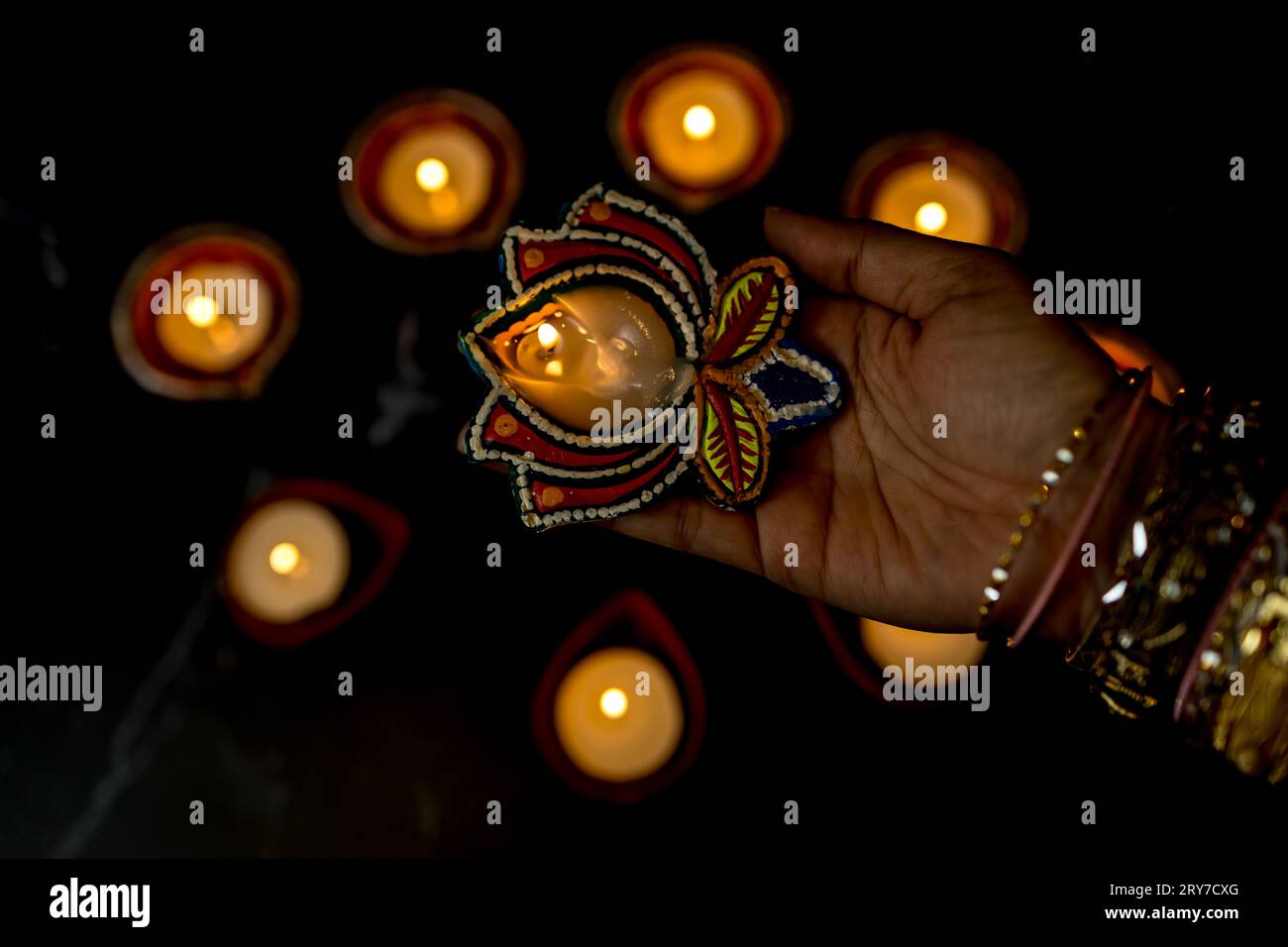 Happy Diwali - Woman hands with henna holding lit candle isolated on ...
