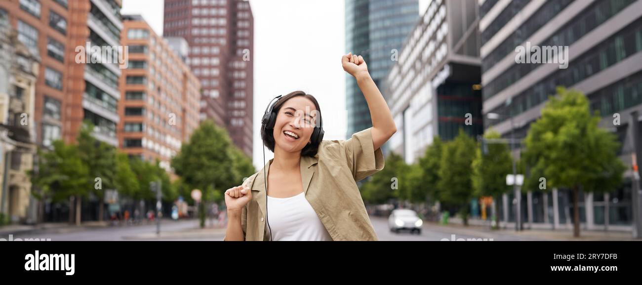 Portrait of smiling asian woman dancing, triumphing, feeling happy ...