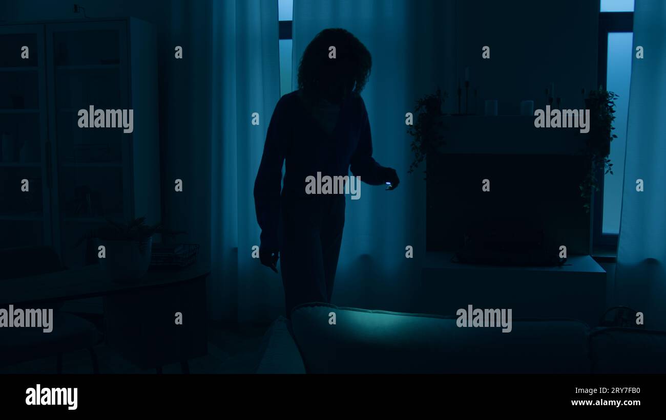 Woman girl lady female walking indoors in dark living room at night ...