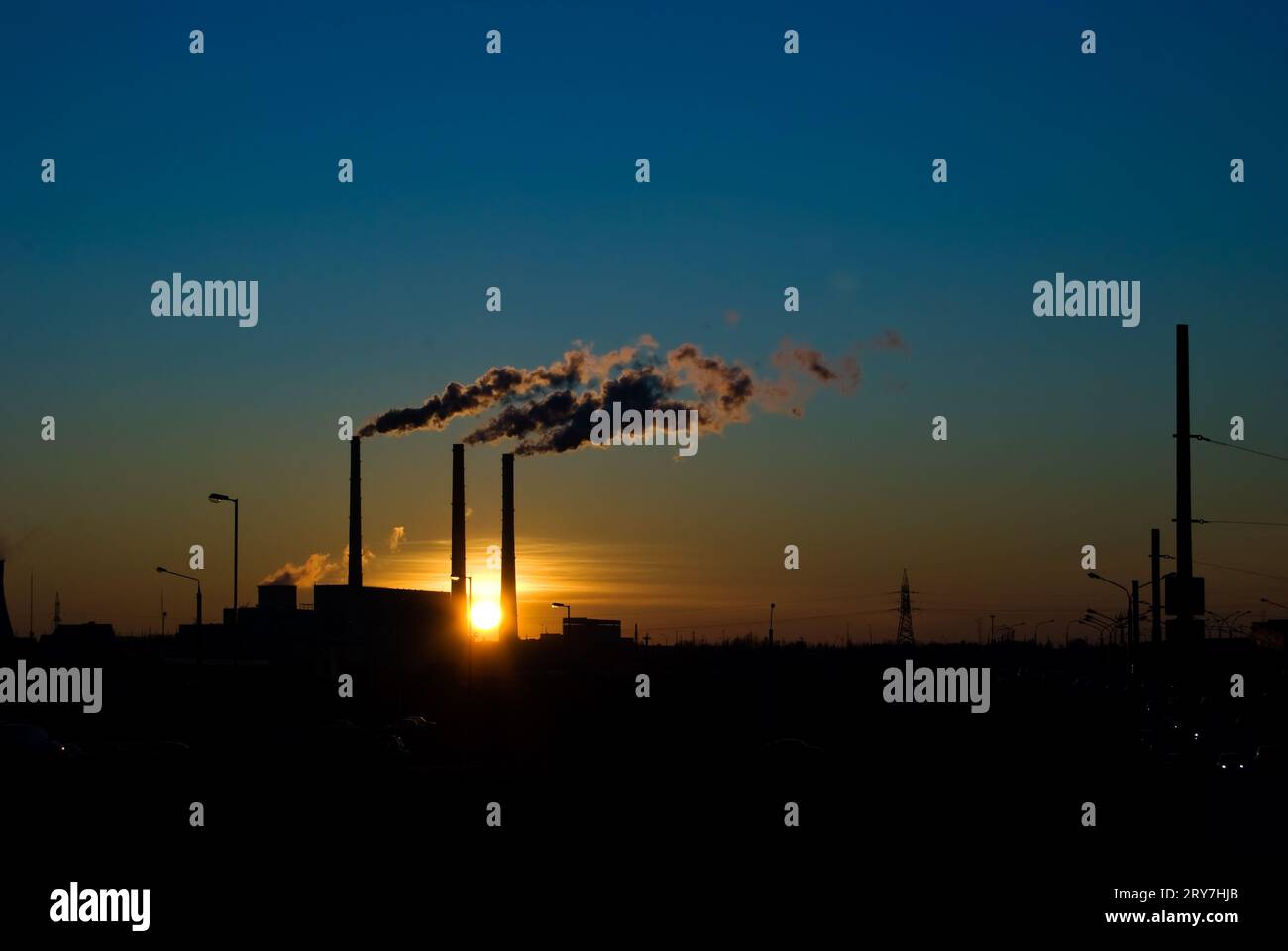 Sunset over smoking pipes of industrial buildings Stock Photo - Alamy