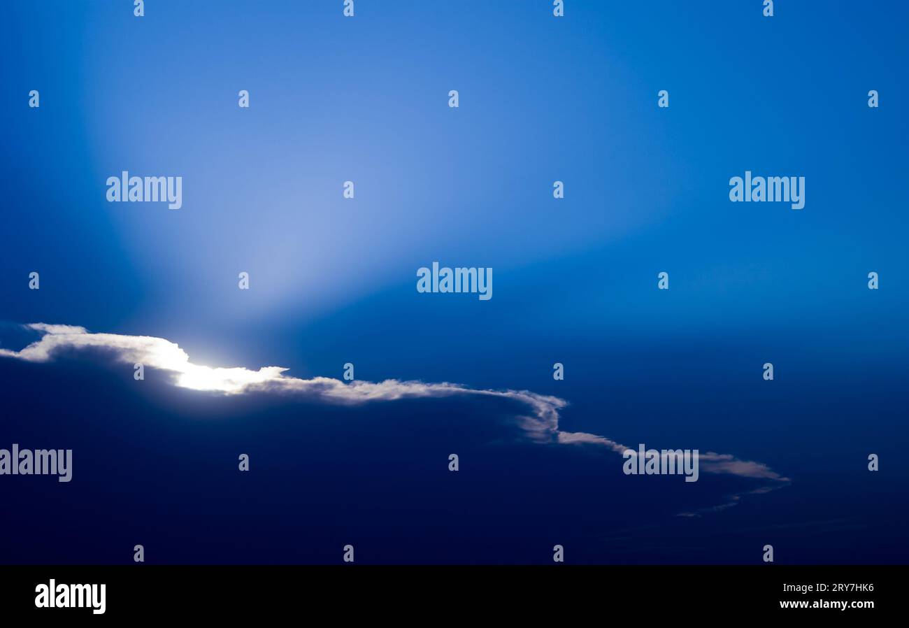 The sun on a sunset disappearing behind the clouds Stock Photo - Alamy