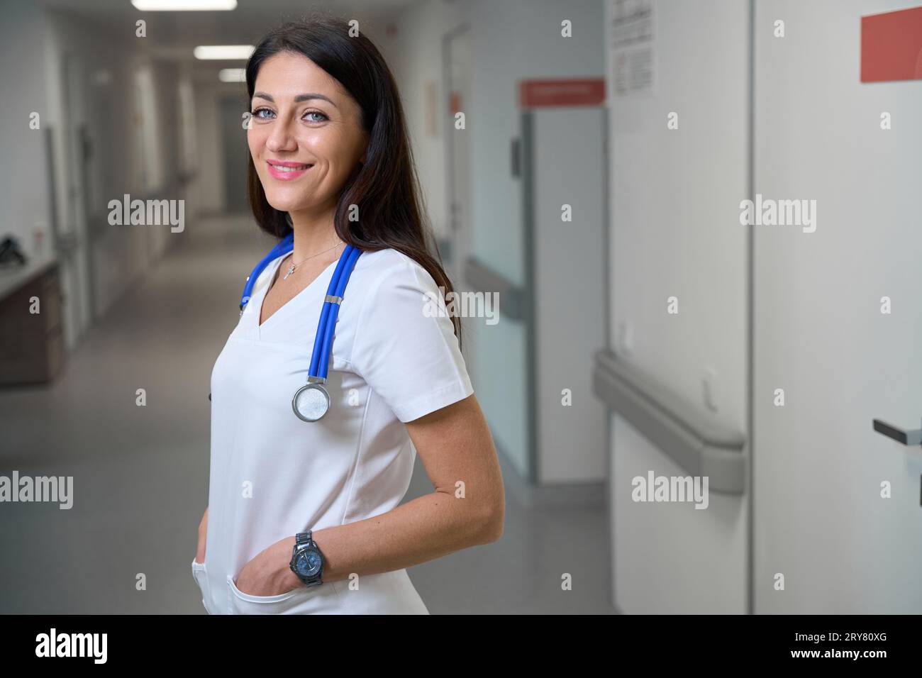 Smiling clinic employee in a bright hospital corridor Stock Photo - Alamy