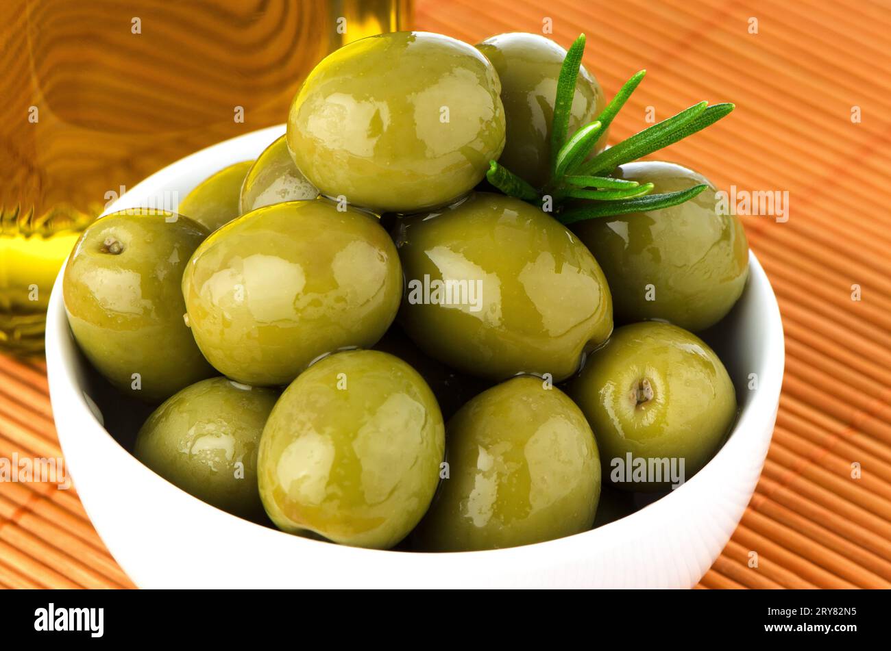Green olives in a white ceramic bowl Stock Photo - Alamy
