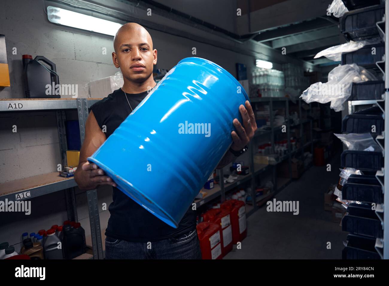 African American guy holding in hands big barrel with paint Stock Photo ...