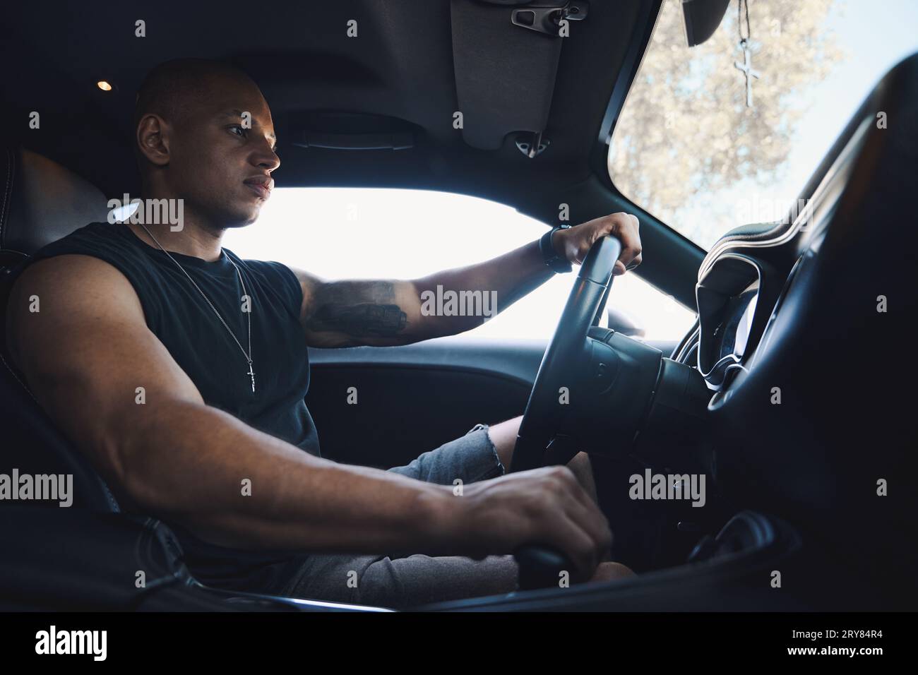 Serious self-confident man participating in street racing on his luxury ...