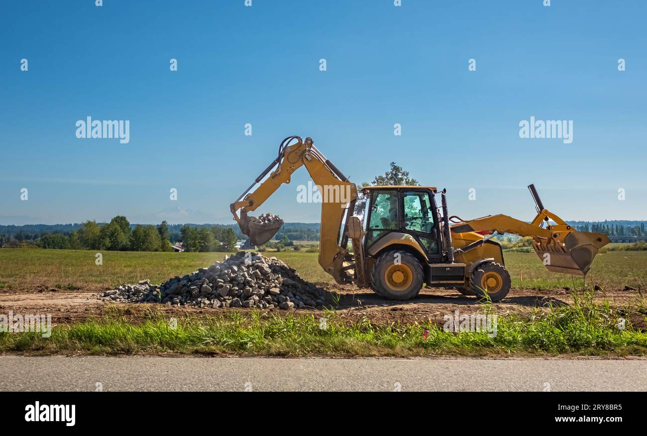 Wheel loader excavator with field background during earthmoving work ...