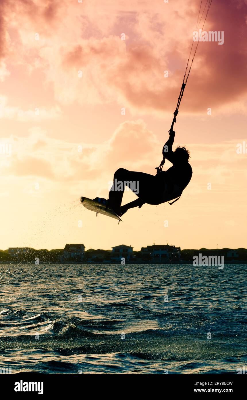 Silhouette of a kitesurfer flying Stock Photo - Alamy