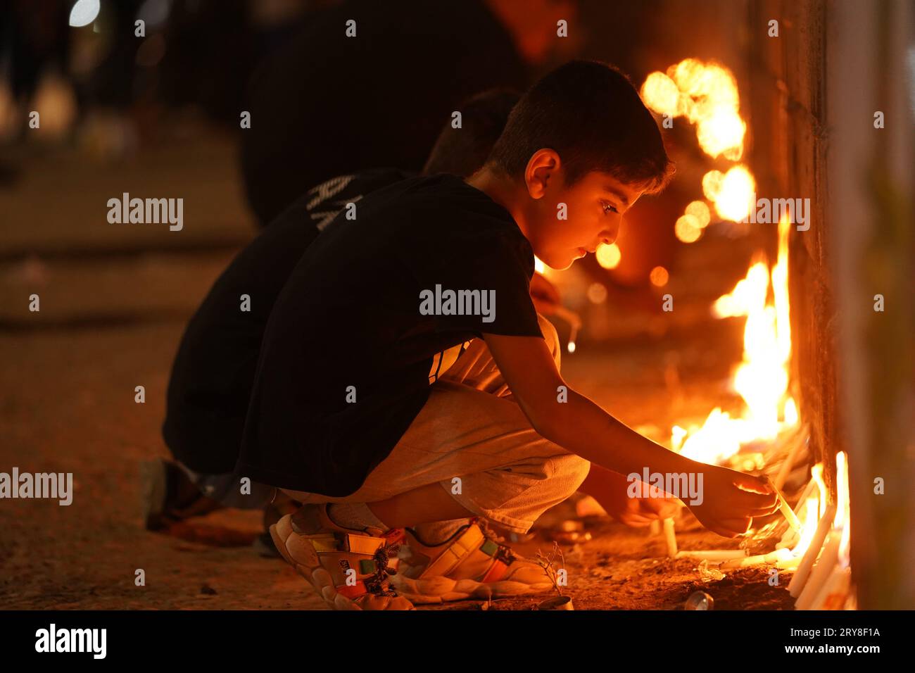 Hamdaniya, Iraq. 29th Sep, 2023. A boy lights candles outside St Mary ...