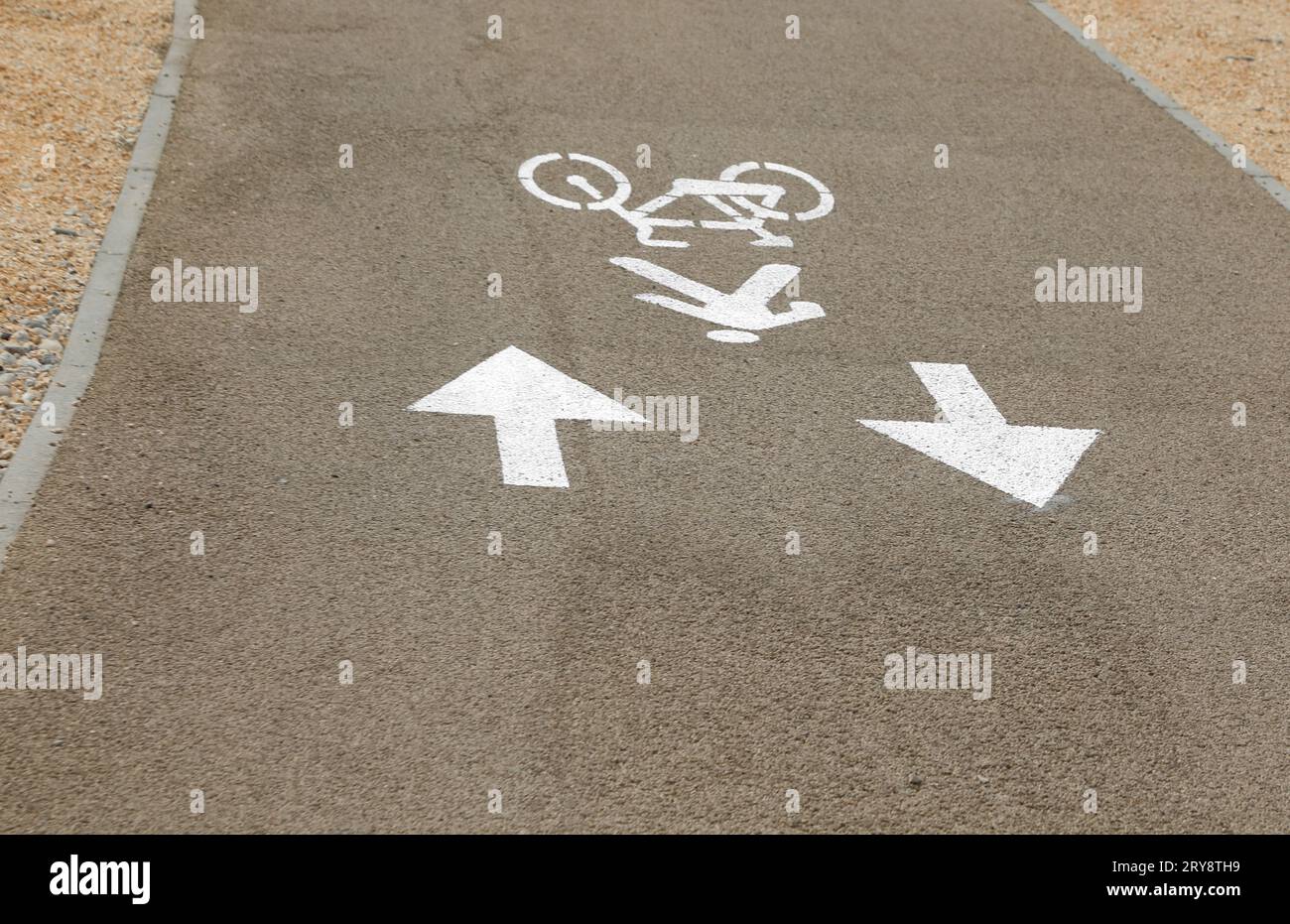 signs painted on the ground on the cycle path with two arrows and also ...