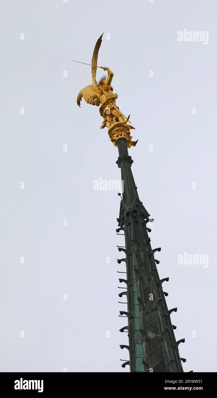 golden angel with sword drawn high and large wings above the tip of the ...