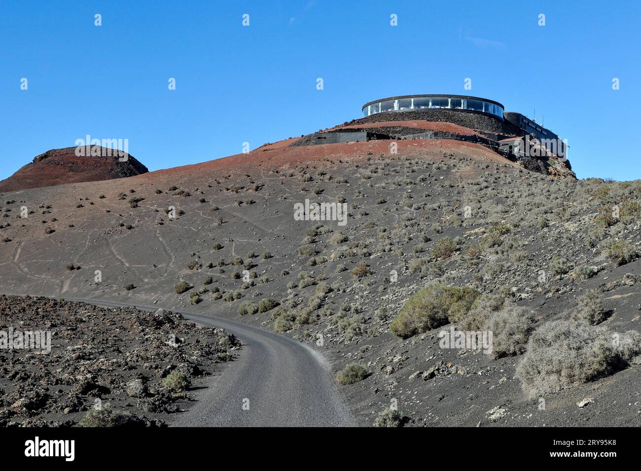 View of volcanic hilltop with tourist centre in Timanfaya National Park ...