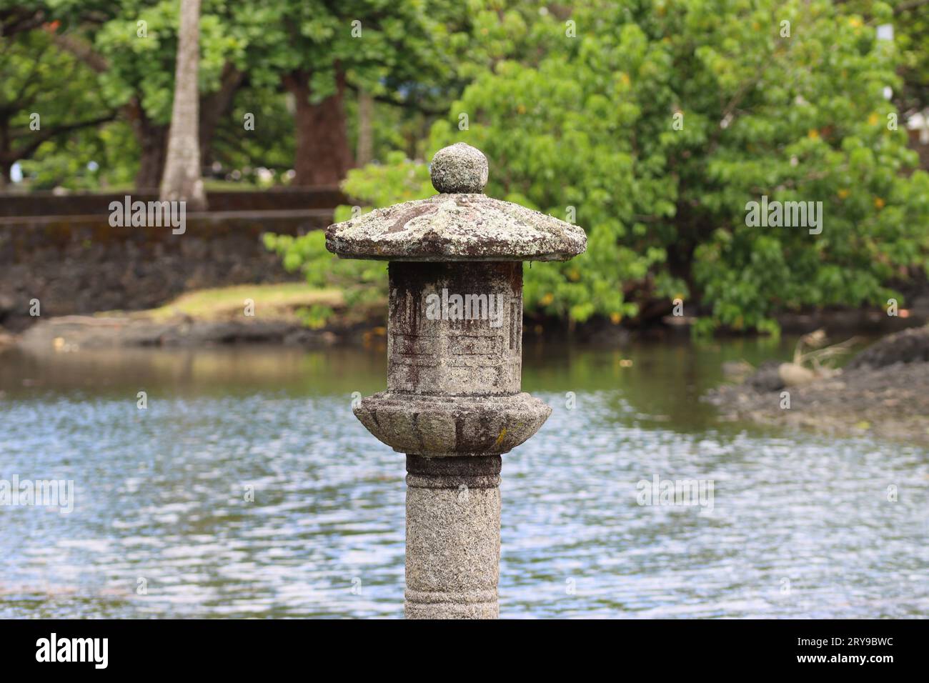 A close up of a traditional toro stone lantern within a Japanese garden ...