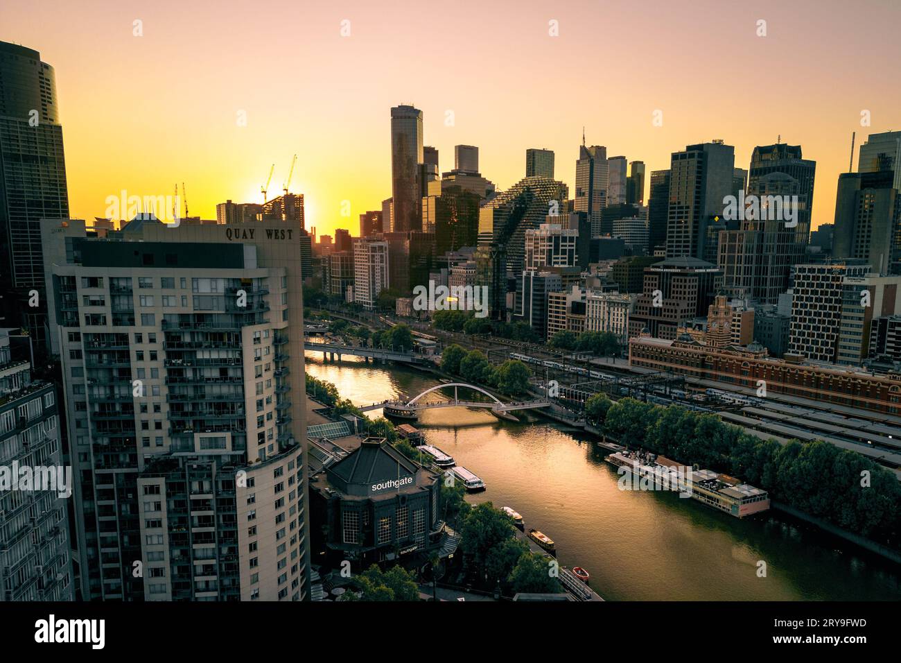 A view of the Yarra River flanked my tall city buidlings, boats moored ...