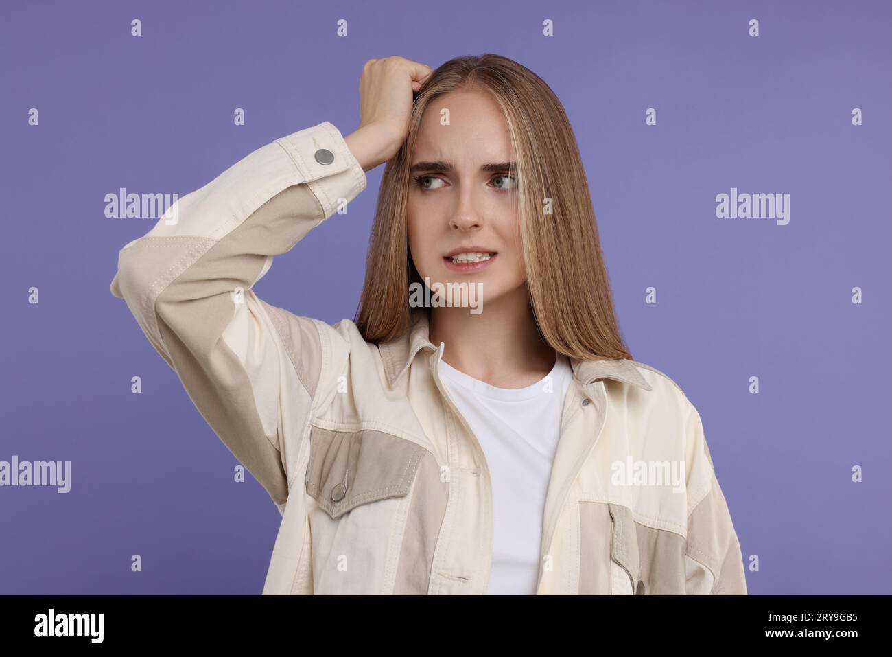 Portrait of embarrassed young woman on violet background Stock Photo ...