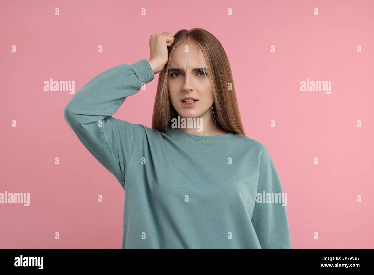 Portrait of embarrassed young woman on pink background Stock Photo - Alamy