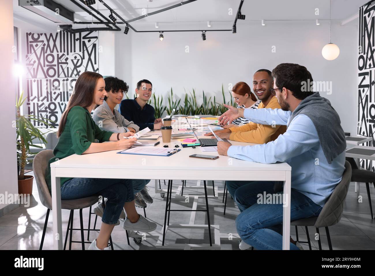 Team of employees working together at table in office. Startup project ...