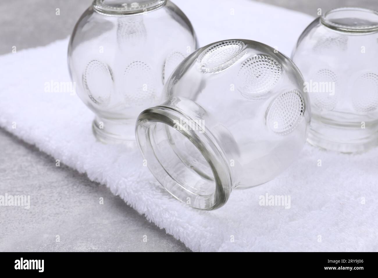 Glass cups and towel on grey table, closeup. Cupping therapy Stock ...
