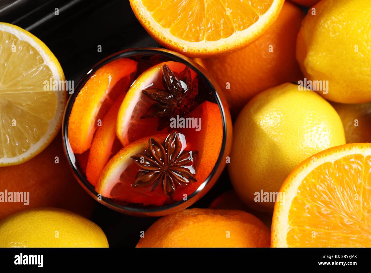 Glass of aromatic punch drink and fresh citrus fruits on table, flat ...