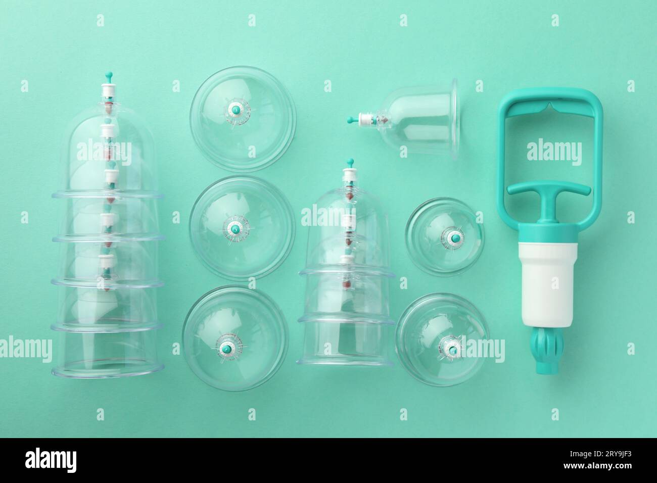 Plastic cups and hand pump on turquoise background, flat lay. Cupping ...
