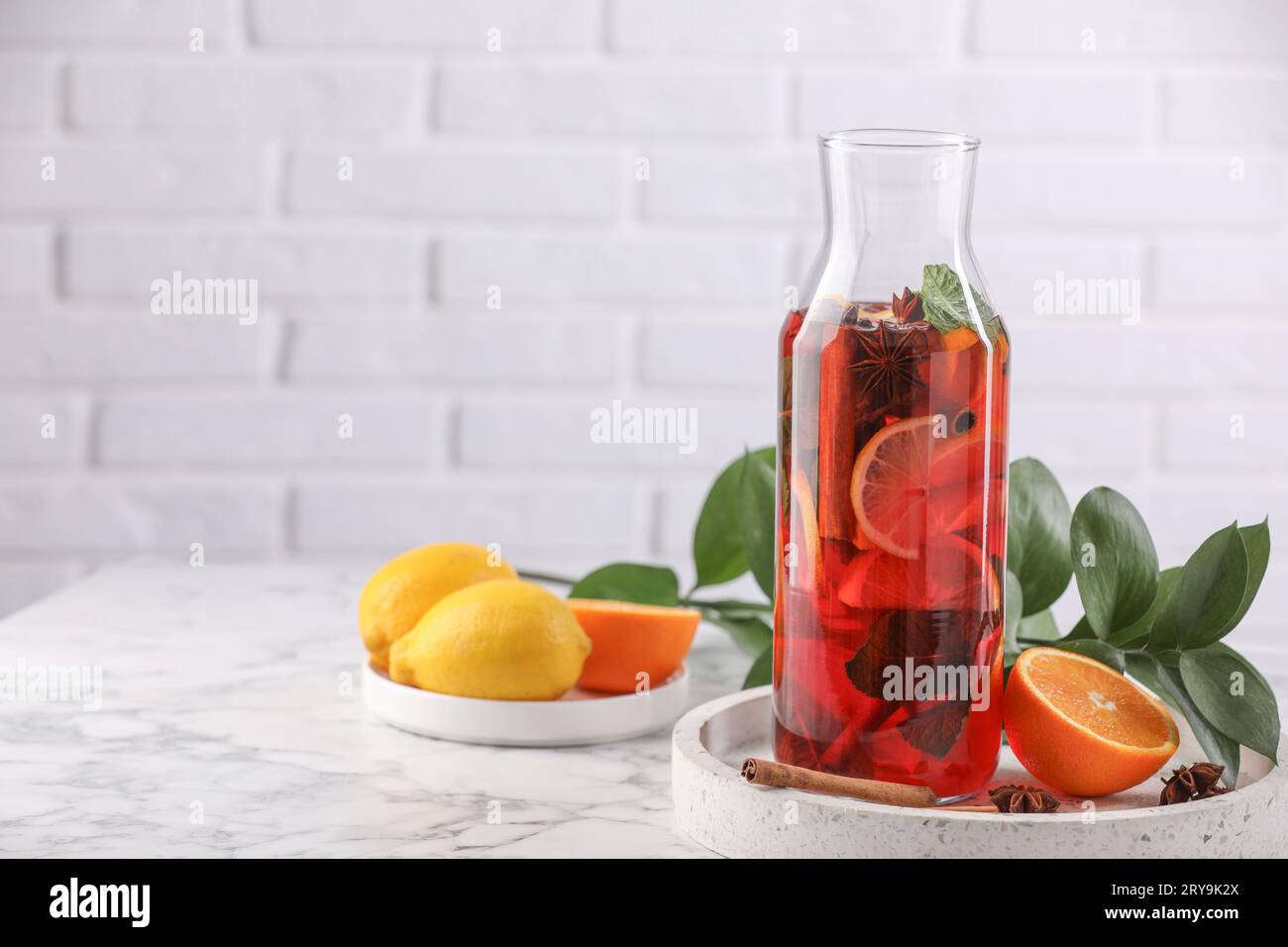 Delicious punch drink in bottle and ingredients on white marble table ...
