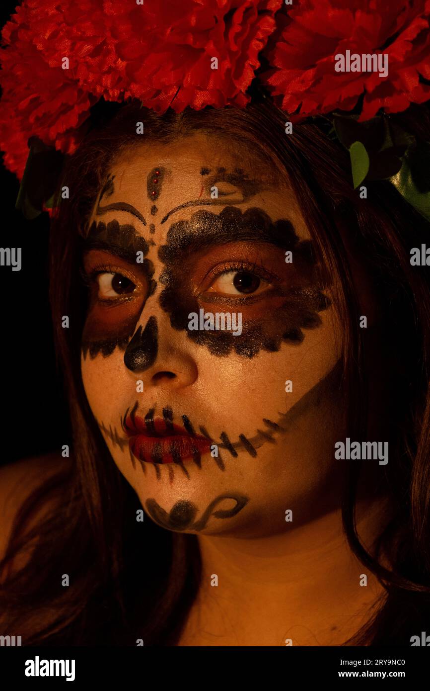 woman staring straight ahead wearing Catrina makeup representing the ...