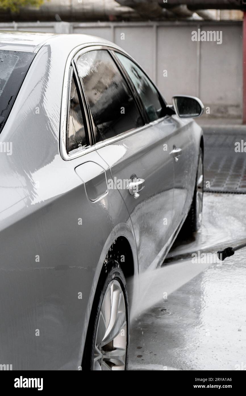 Washing luxury silver car on touchless car wash. Washing sedan car with ...