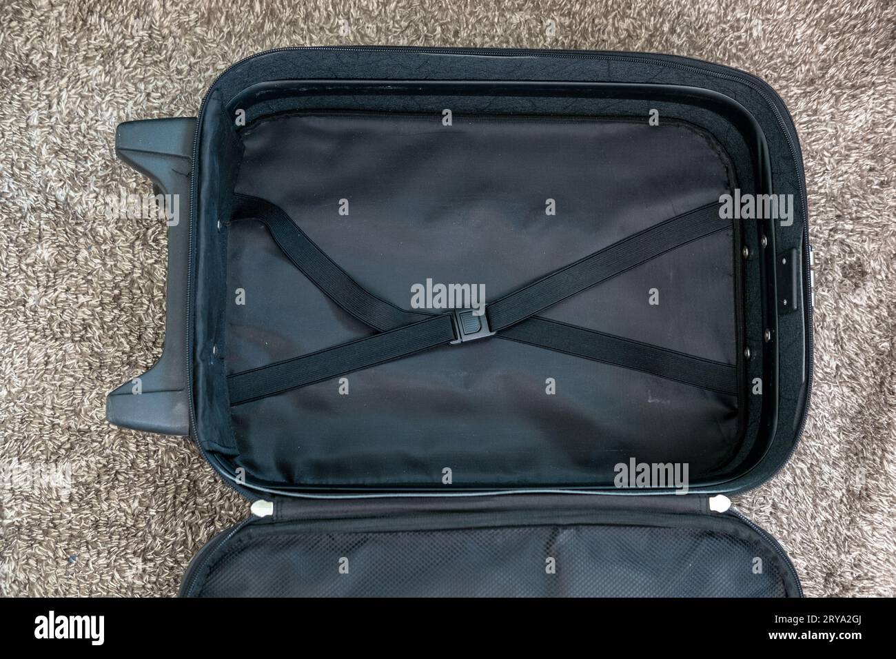 An empty black suitcase lay on the floor, waiting to be loaded Stock ...