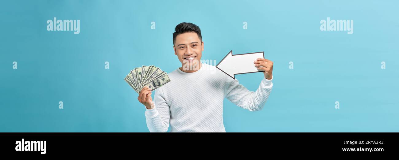 Happy winner man smiling and pointing arrow on fan of money banknotes ...