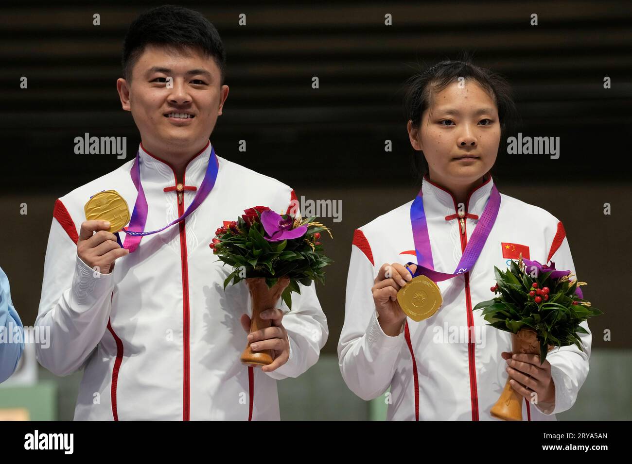 China's Jiang Ranxin, right and Zhang Bowen celebrate with their medals during the awards ...