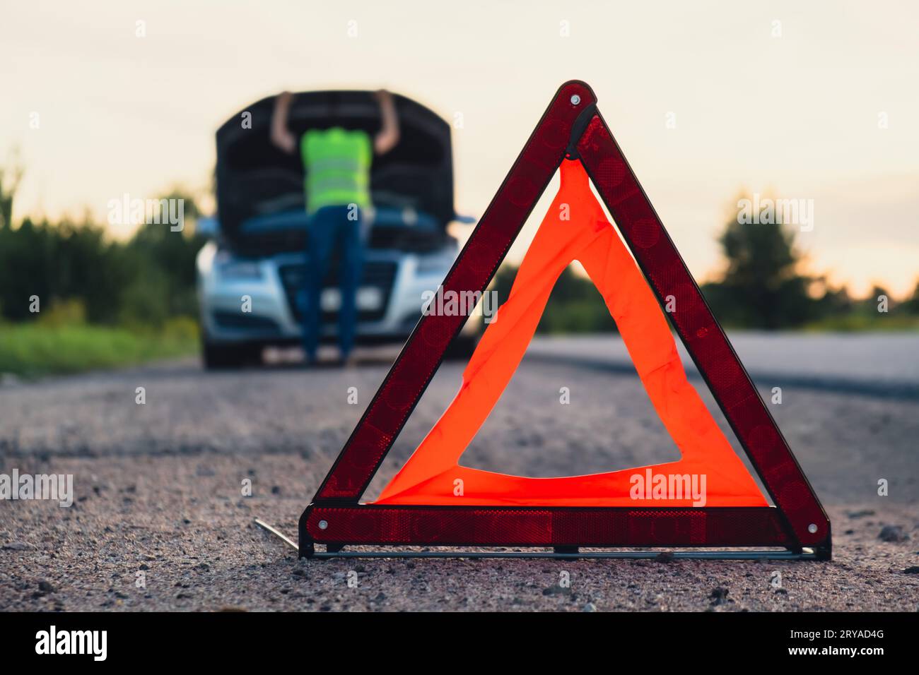 Broken silver luxury car emergency accident. Man driver installing red ...