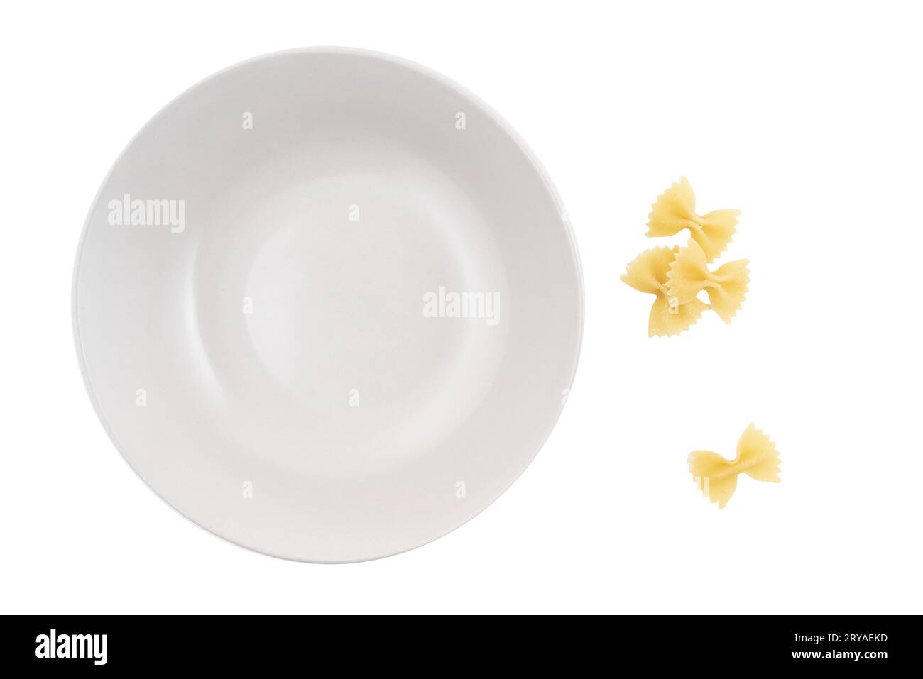 Three pieces of dried butterfly format pasta and an empty plate Stock ...