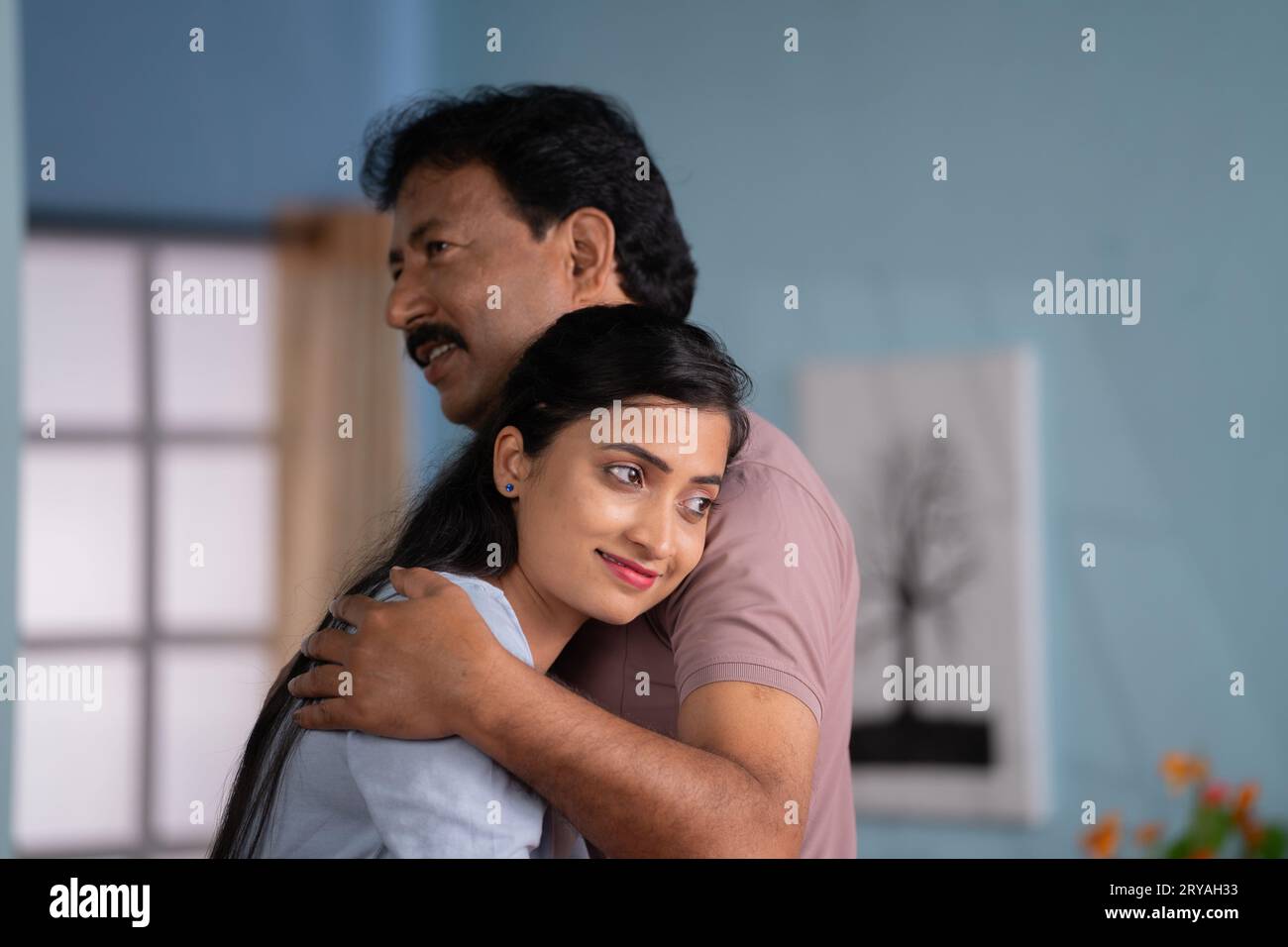 Happy smiling indian daughter meeting her father by hugging or ...