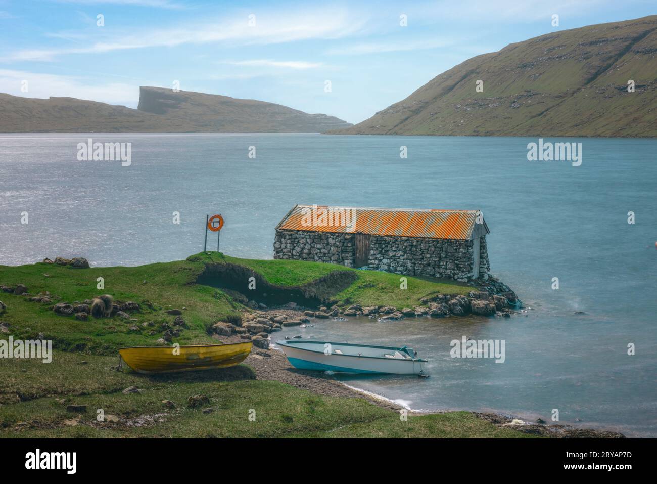 traditional boathouses at the lake Sørvágsvatn near Sandavagur on the ...