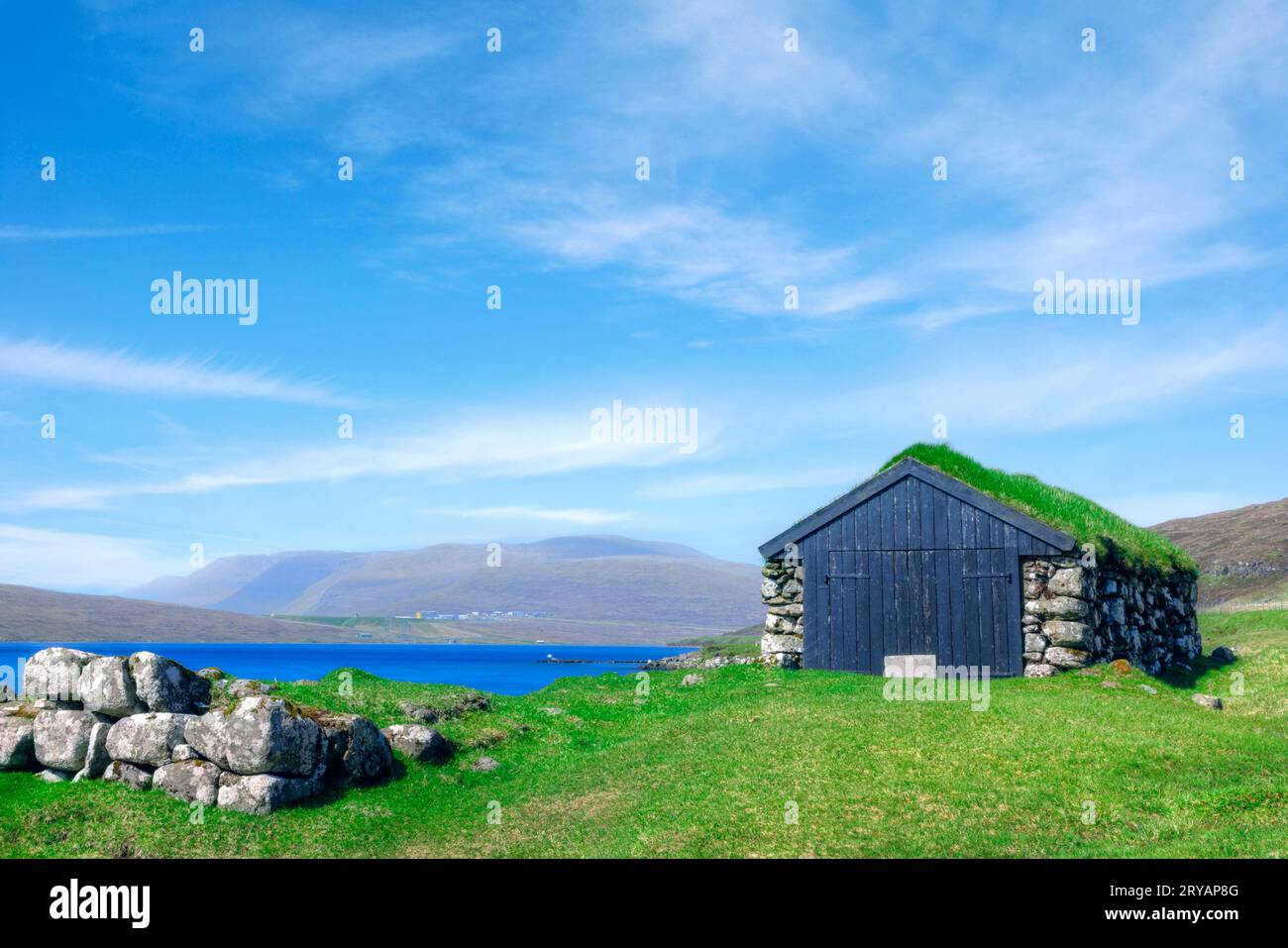 traditional boathouses at the lake Sørvágsvatn near Sandavagur on the ...