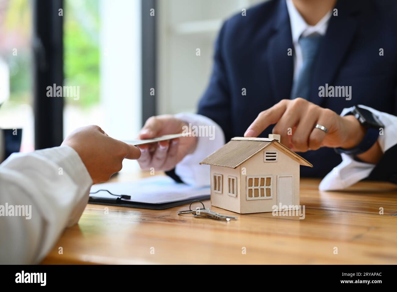 Male real estate agent receiving money from a client after signing ...