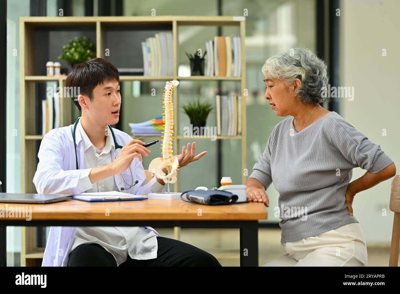 Orthopedist giving consultation about scoliosis or spinal problems to ...