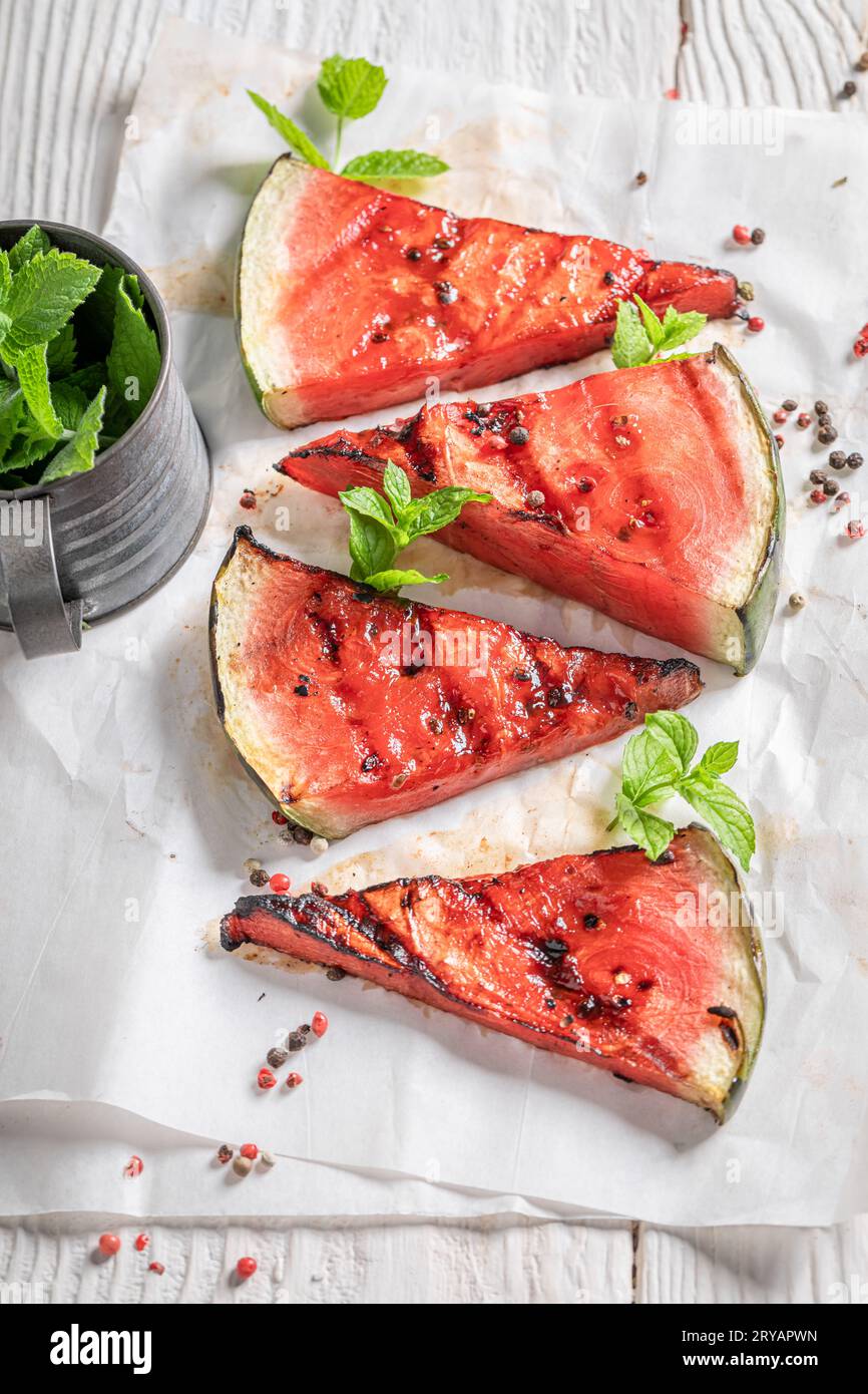 Roasted watermelon on grill grate with fire. Grilled watermelon on ...