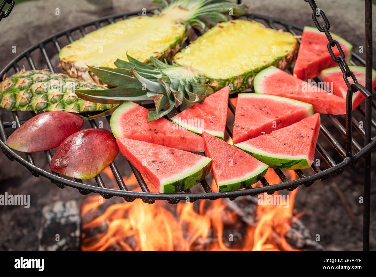 Roasted watermelon and pineapple in the summer garden. Grill with fire ...