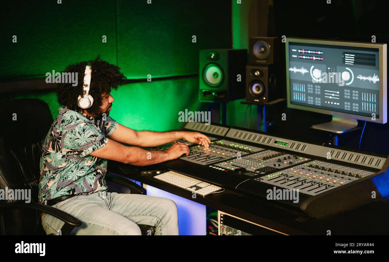Young audio engineer mixing a sounds in music recording studio - Youth ...