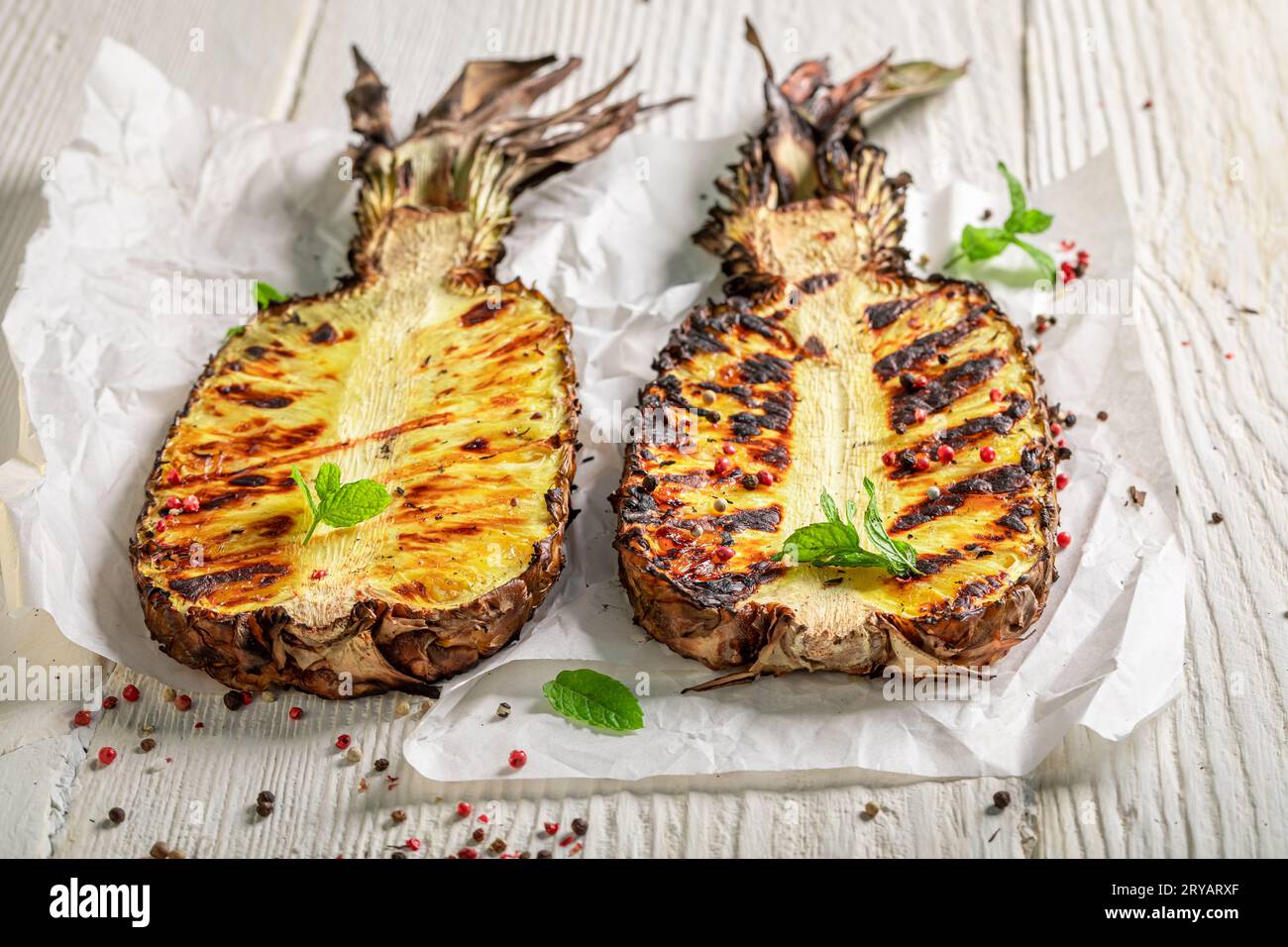 Burned pineapple on grill grate with fire. Roasted pineapple on grill ...