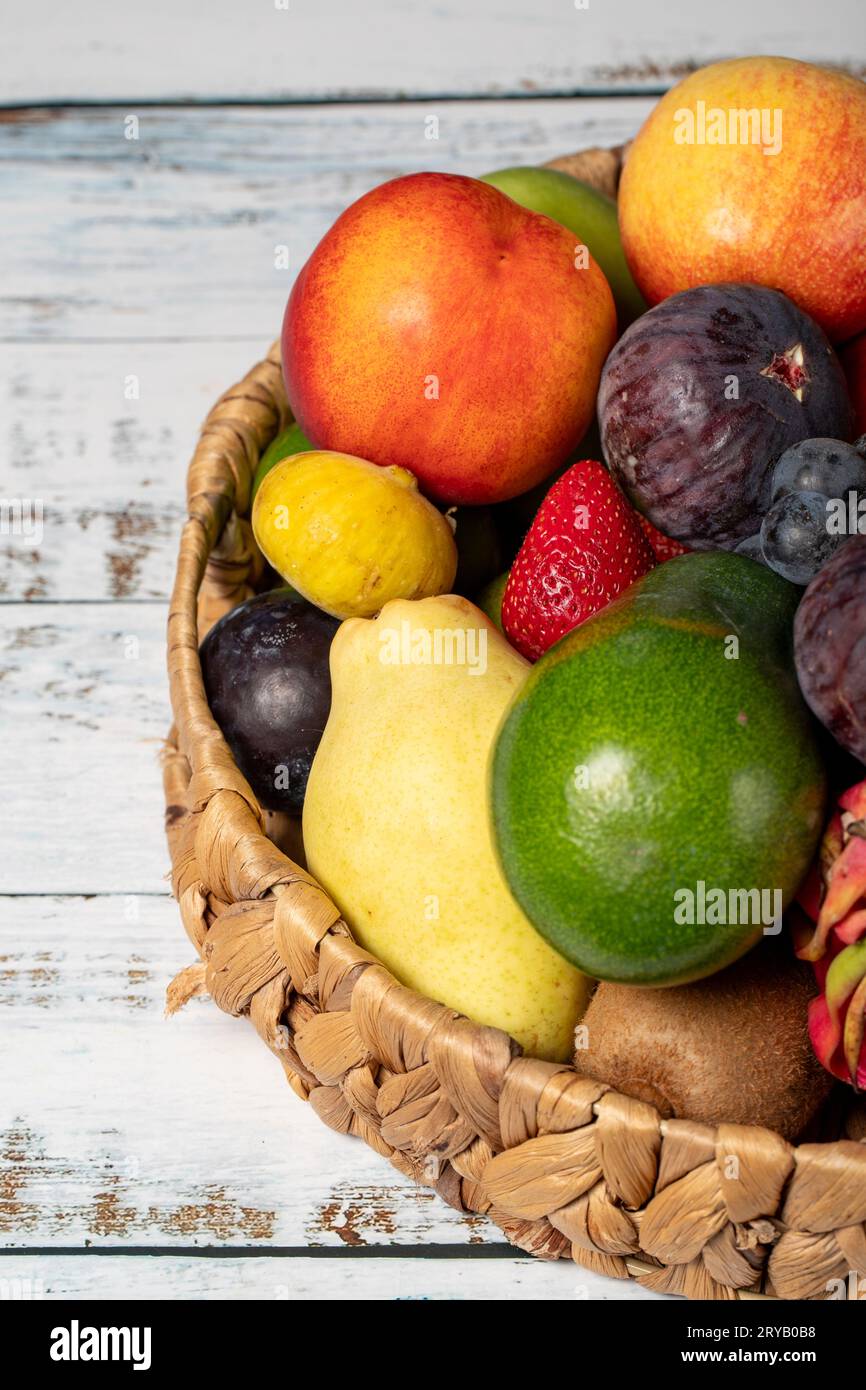 Fresh fruits in a wicker basket. Various colorful fruits. Vertical view ...
