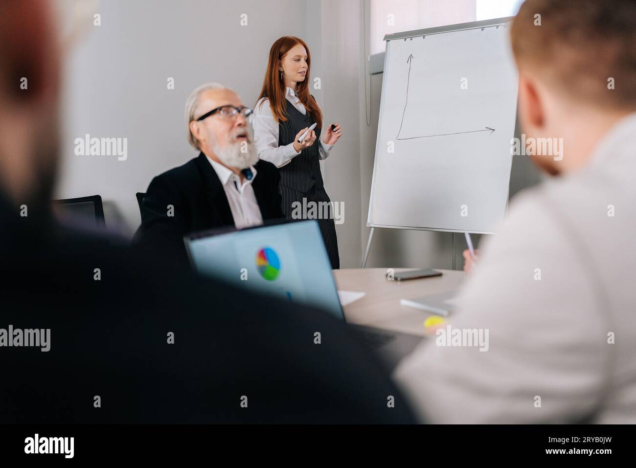 View from back of colleagues to female executive leader coach presenter ...