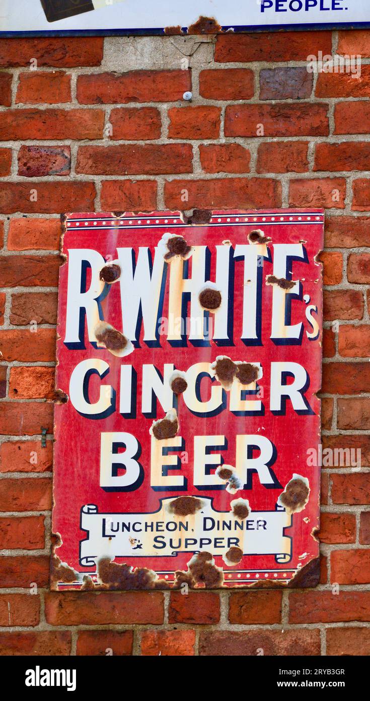 A colour photograph of a vintage metal sign advertising R White's ...