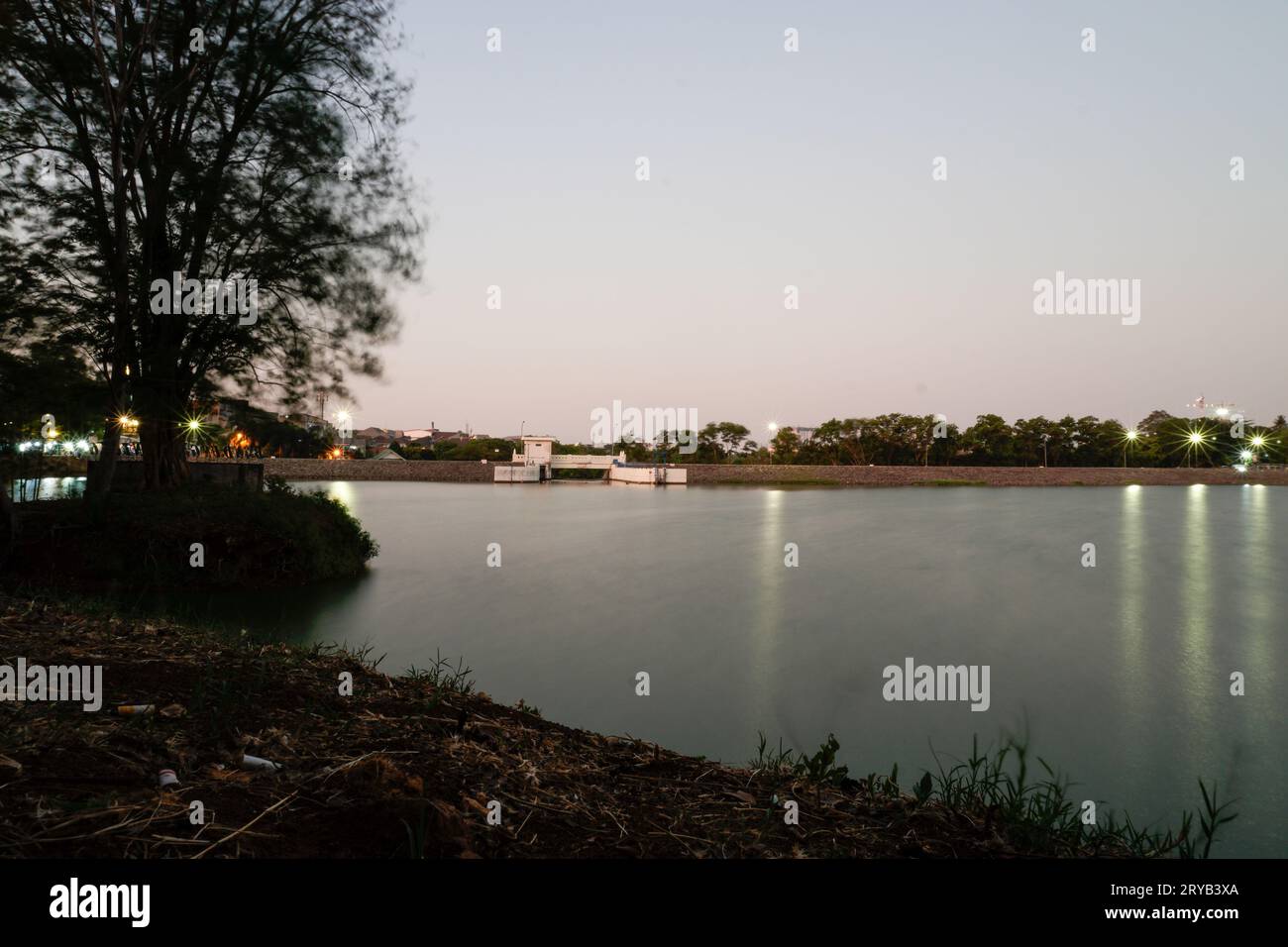 The edge of the lake is surrounded by shady trees, the horizon is ...