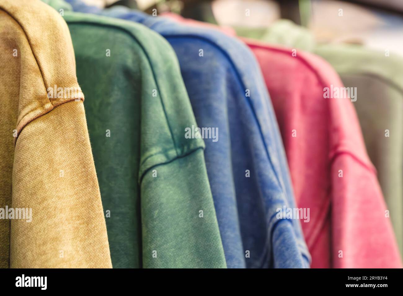 Fashion hoodie clothes on clothing rack Closeup of rainbow color choice ...