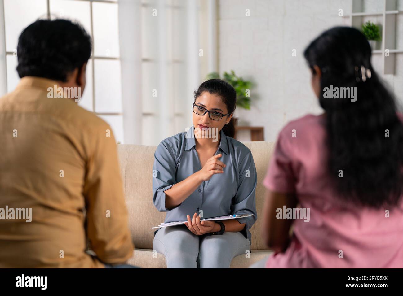 Shoulder shot, Indian psychologist advising to middle aged couple at ...