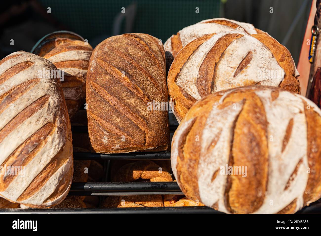 Sourdough bread with crispy crust on wooden shelf. Bakery goods , Different kinds of fresh bread ...