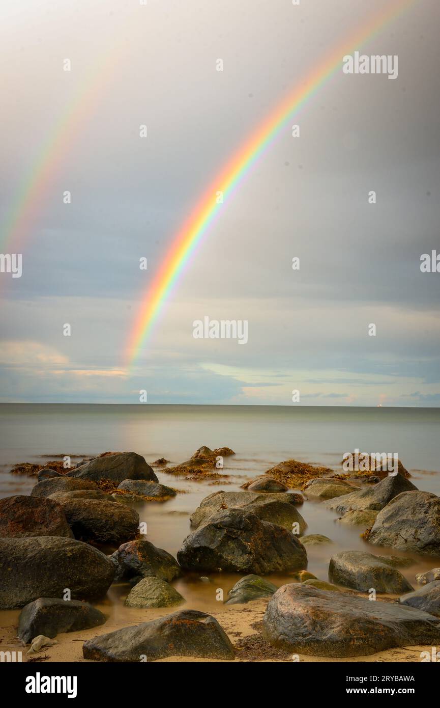 long exposure of rocks in the ocean with a rainbow Stock Photo - Alamy